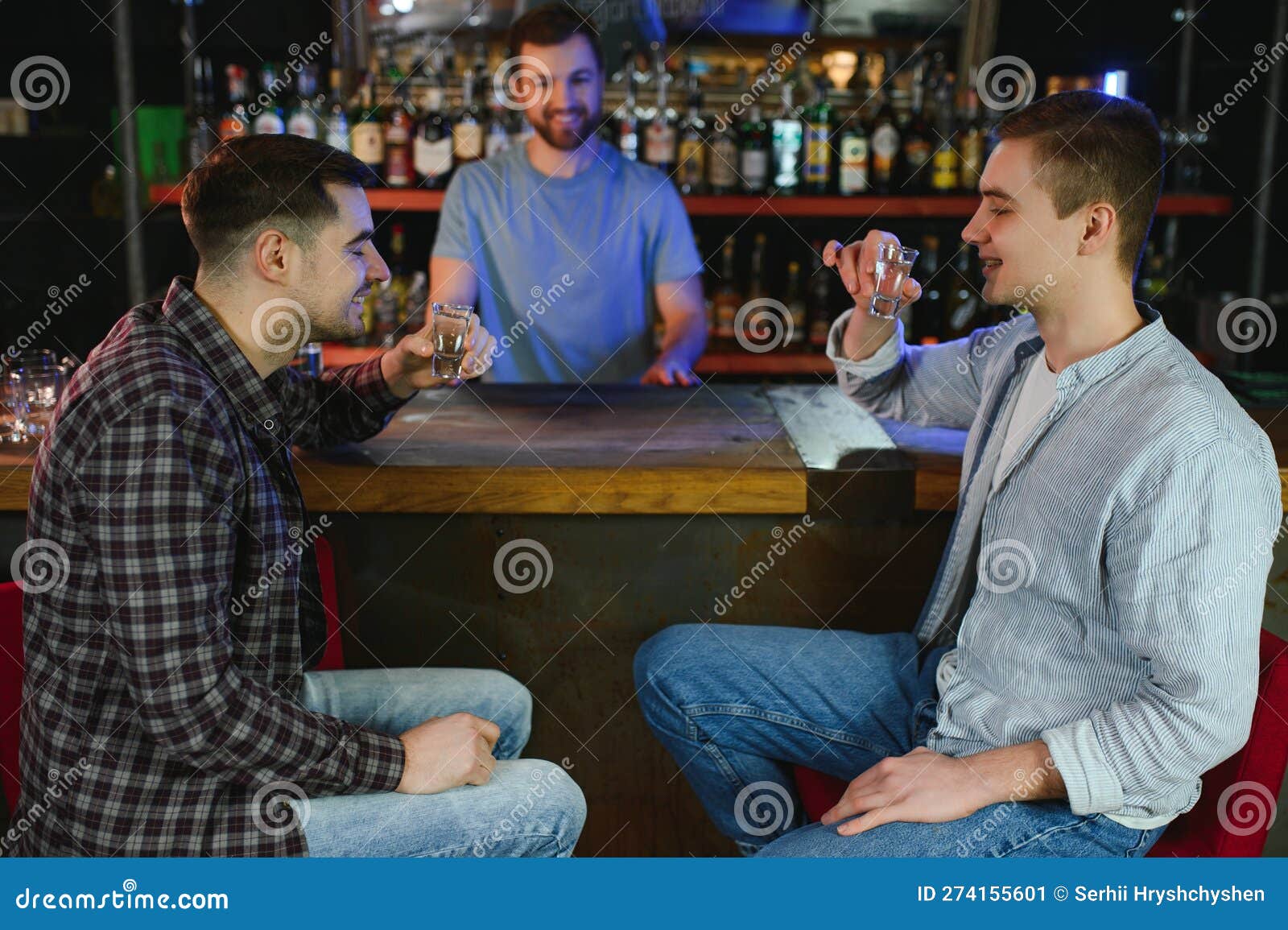 Attractive Bartender is Smiling and Taking Order of Two Men Sitting at ...