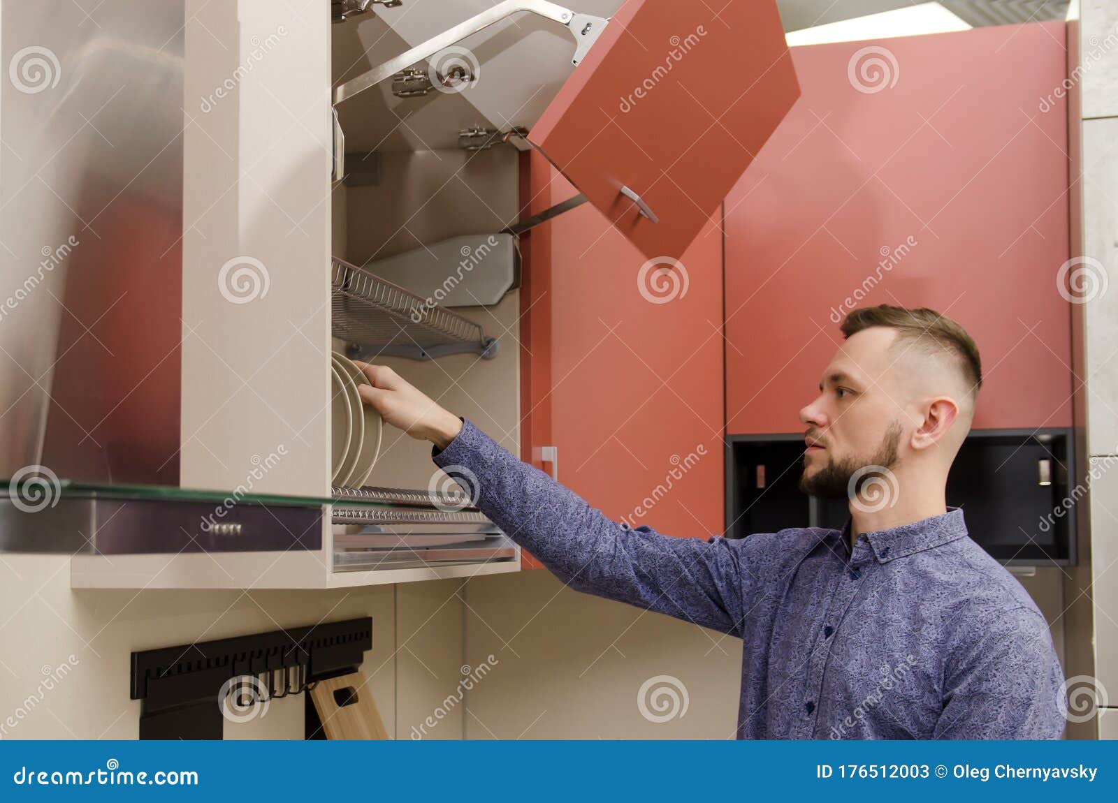Attractive Bearded Man Pulls Out a Plate from a Drying Cupboard in a ...