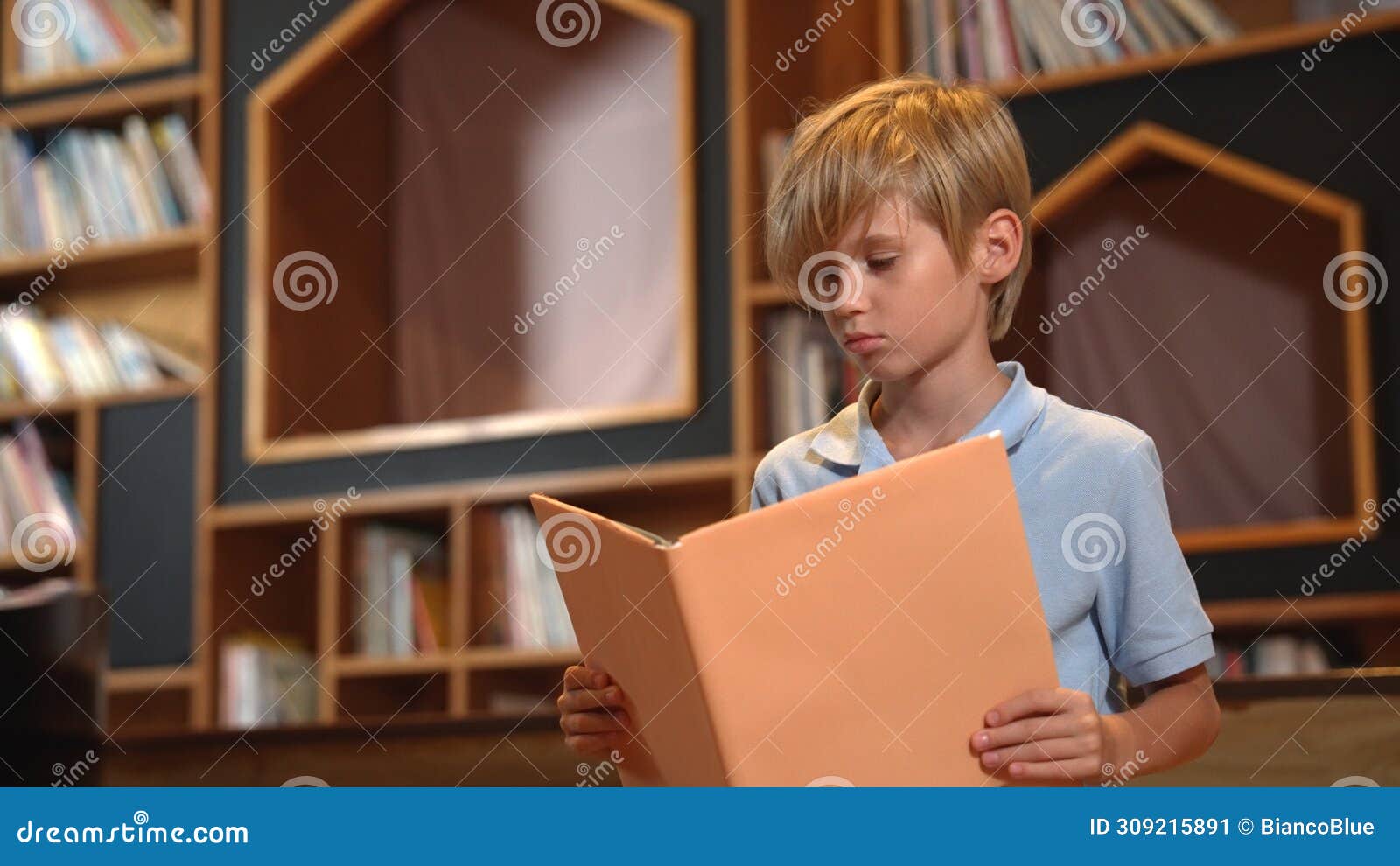 Attractive Boy Reading Book while Group of Students Learning Behind ...