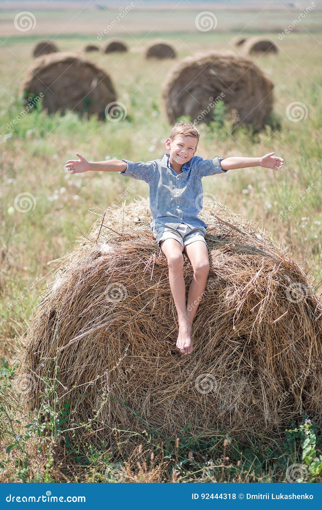 Attractive Boy Sitting on a Haystack and Smiling Stock Photo - Image of ...