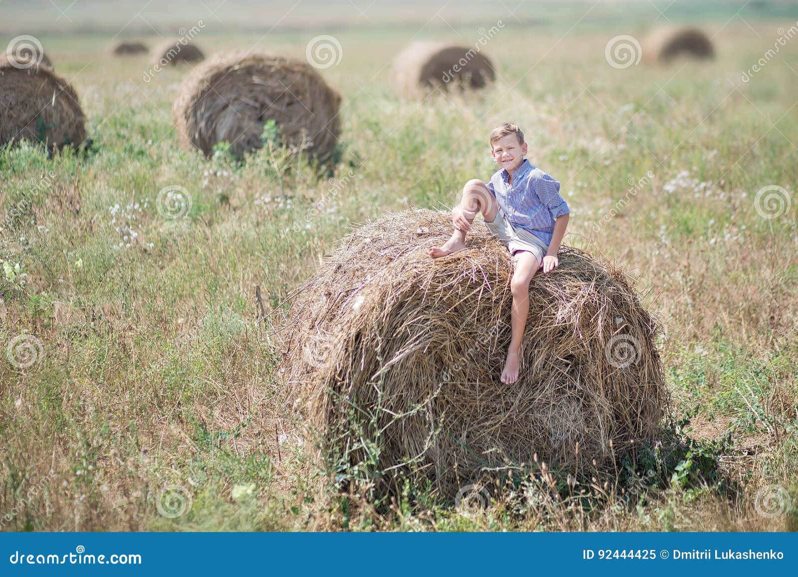 Attractive Boy Sitting on a Haystack and Smiling Stock Image - Image of ...
