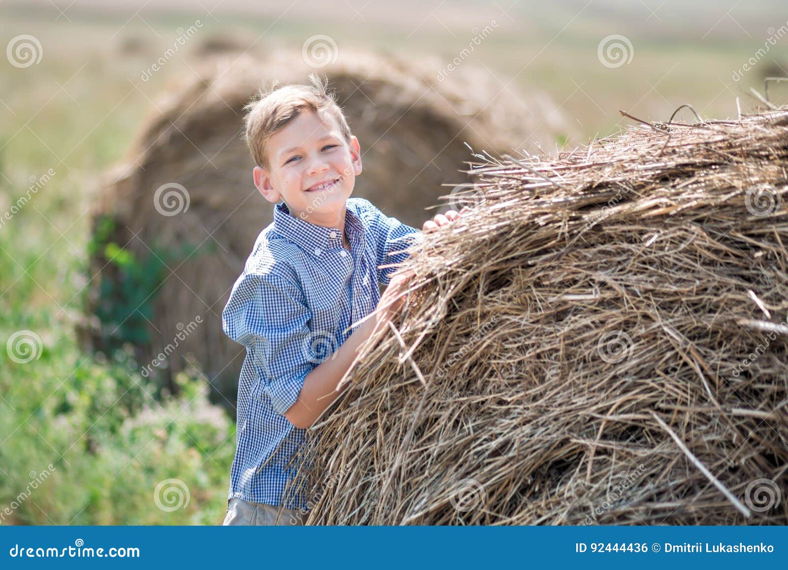 Attractive Boy Sitting on a Haystack and Smiling Stock Photo - Image of ...