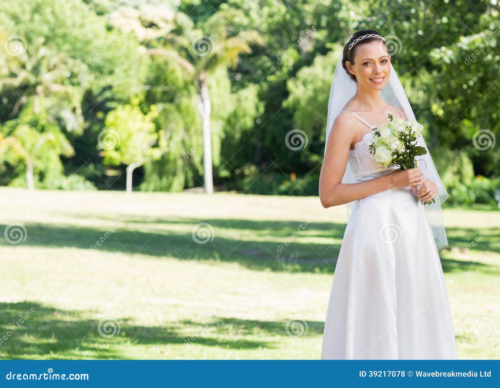 Attractive Bride Holding Flowers in Park Stock Photo - Image of ...