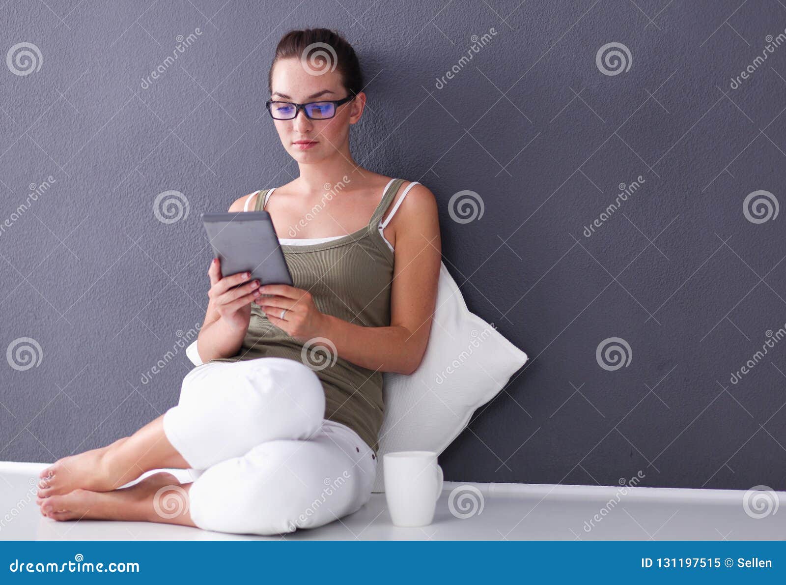 Attractive Caucasian Girl Sitting On Floor With Cup And Tablet Near