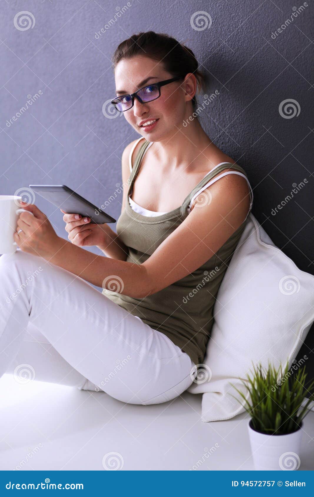Attractive Caucasian Girl Sitting On Floor With Cup And Tablet Near