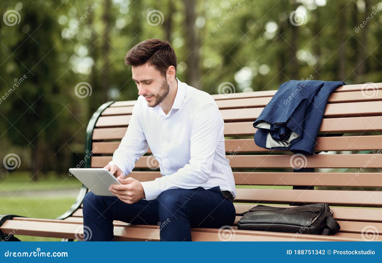 Attractive Company Employee Relaxing on Bench at Park and Browsing ...