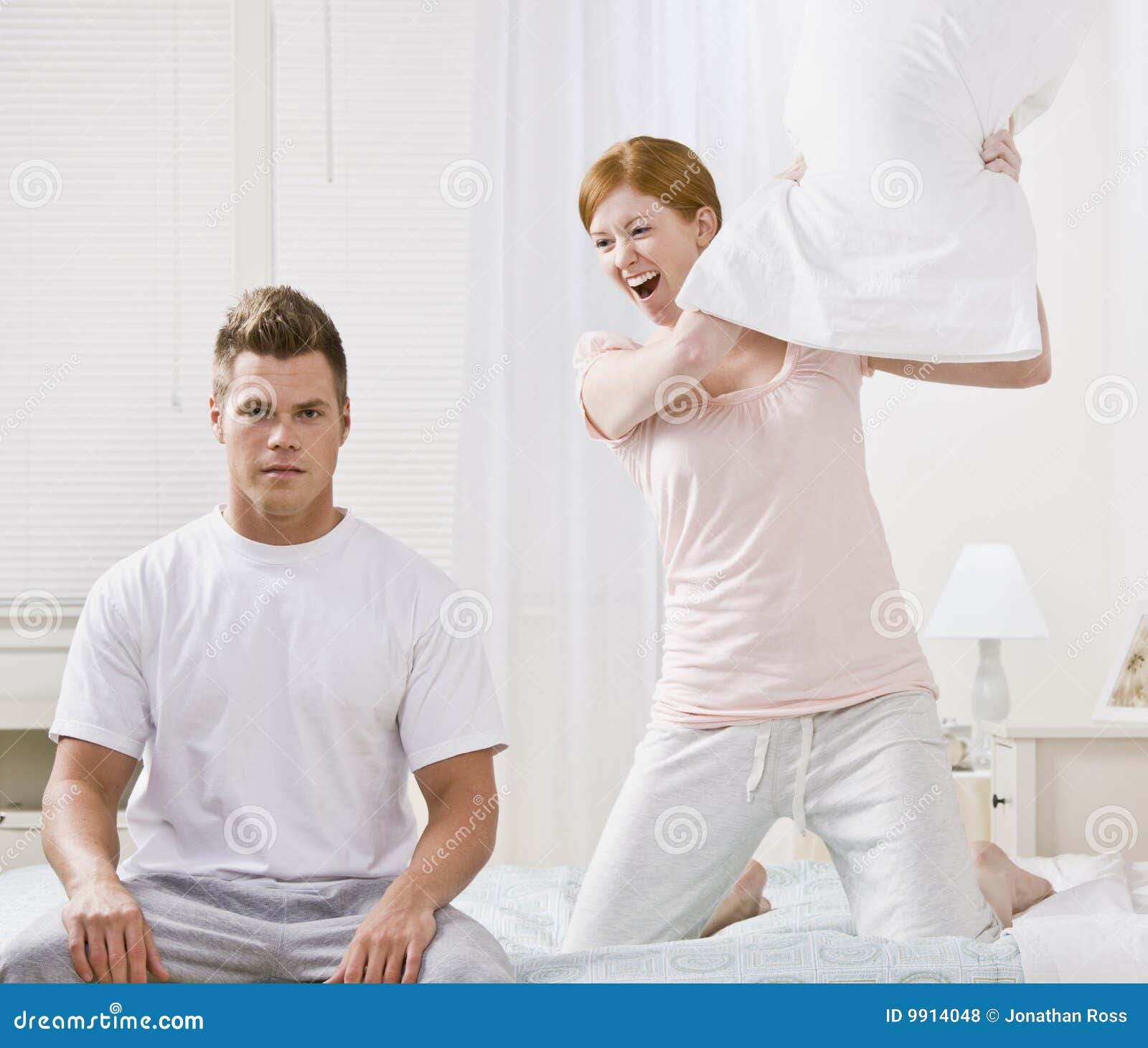 Attractive Couple Having A Pillow Fight Stock Photo - Image: 9914048