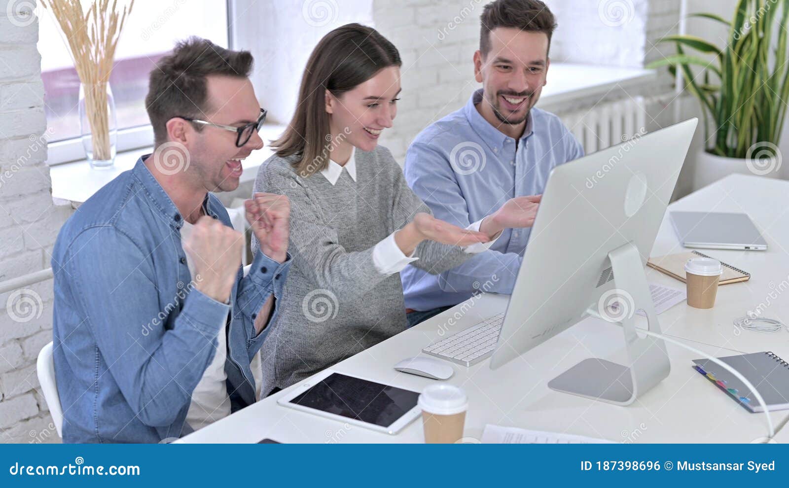 Attractive Creative Team Celebrating Success on Desktop Stock Photo ...