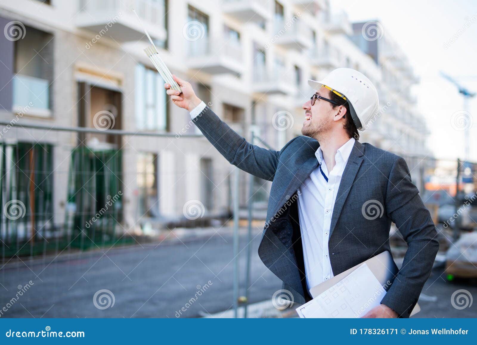 An Architect / Civil Engineer at Work on a Construction Site, Holding ...