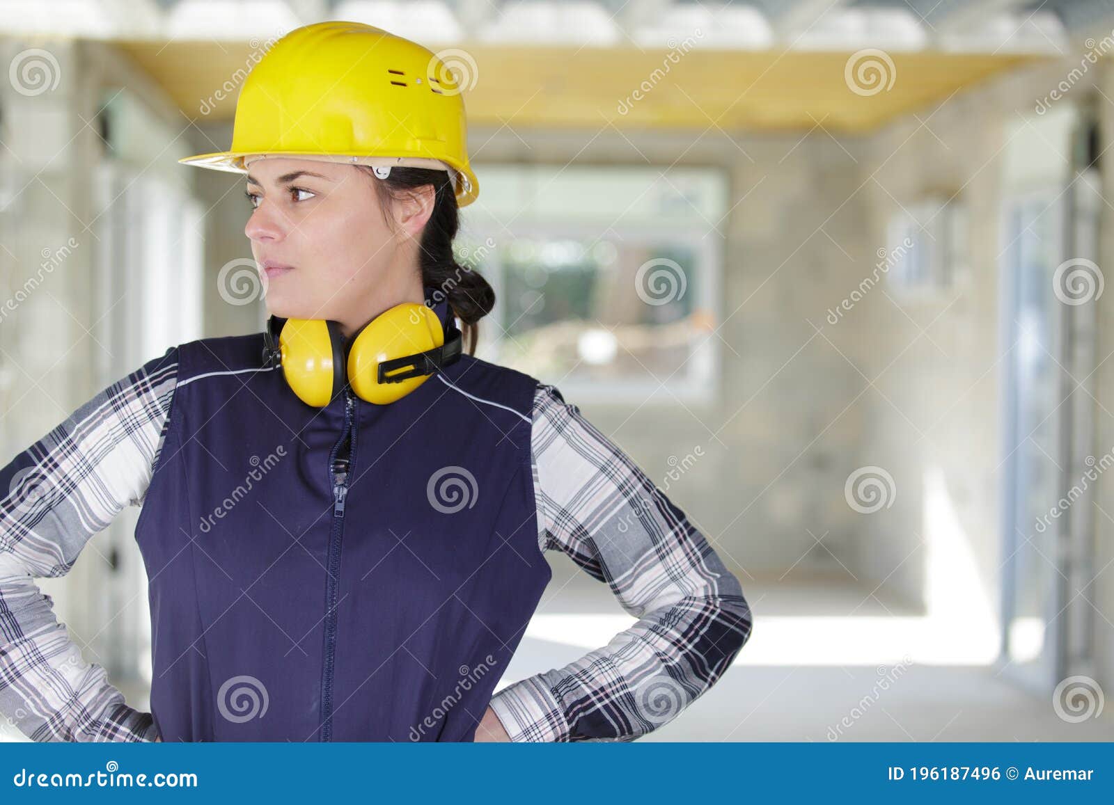 A Female Builder Worker At A Construction Site Works And Controls The ...