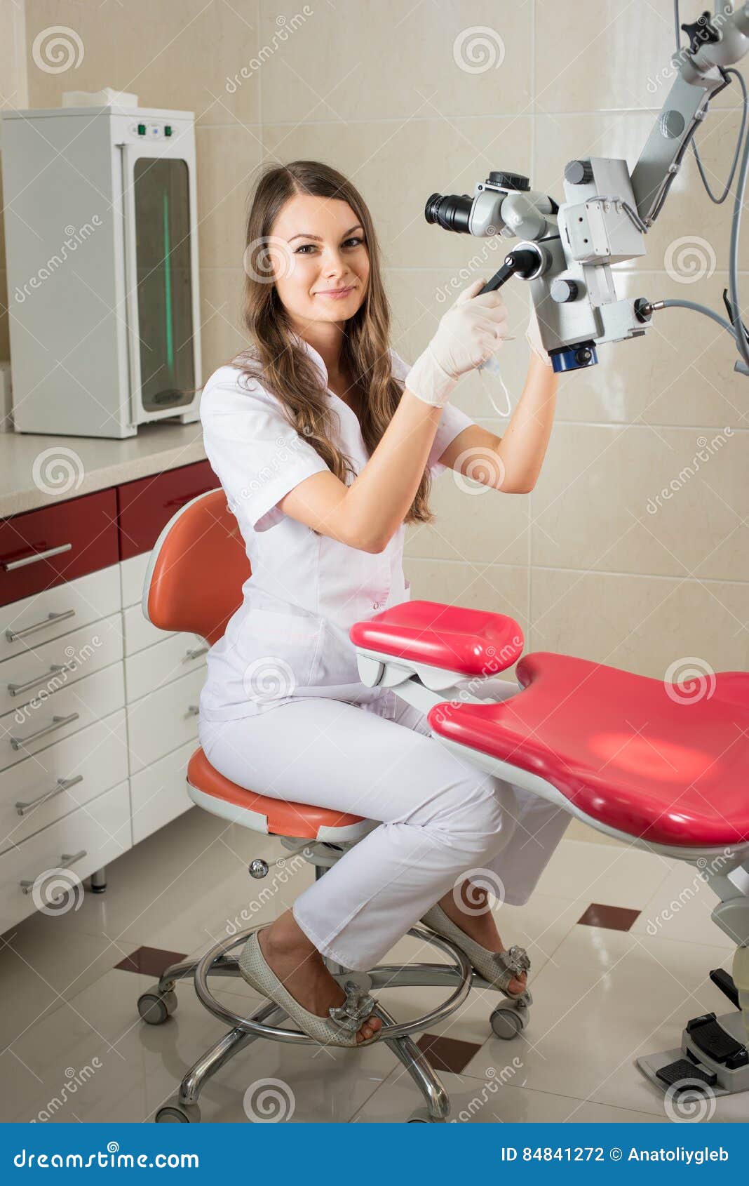Attractive Female Doctor with Microscope in the Modern Dentist Office ...