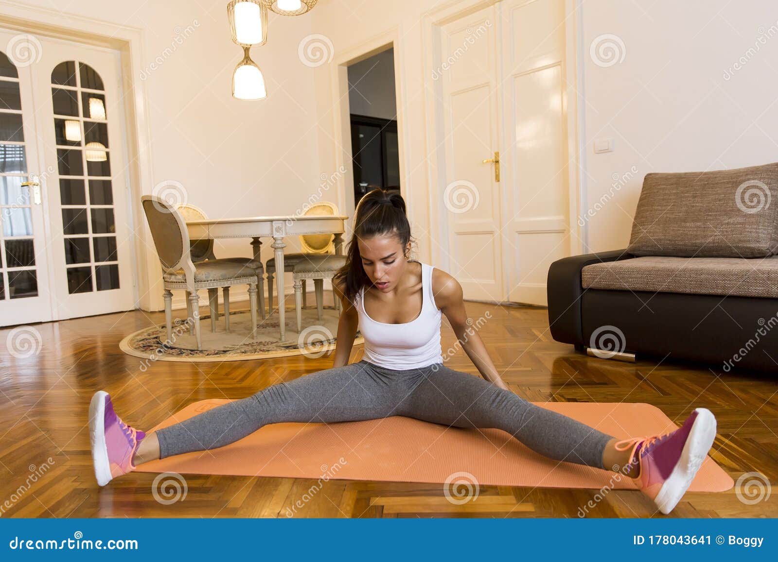 Attractive Female Doing Stretching Exercise in Her Living Room Stock ...
