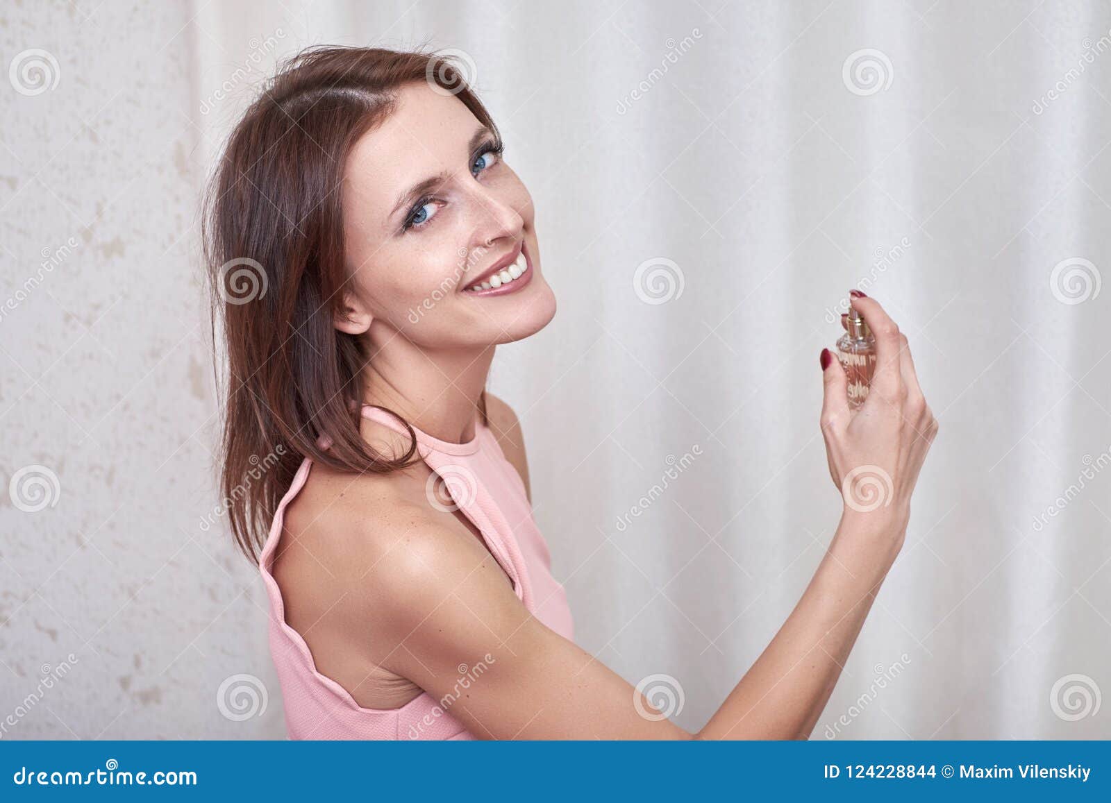An Attractive Female Spraying Perfume on Herself. Stock Photo - Image ...