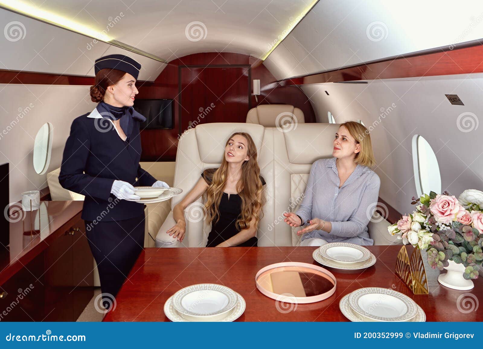 Attractive Flight Attendant is Serving Passengers of First Class Inside ...