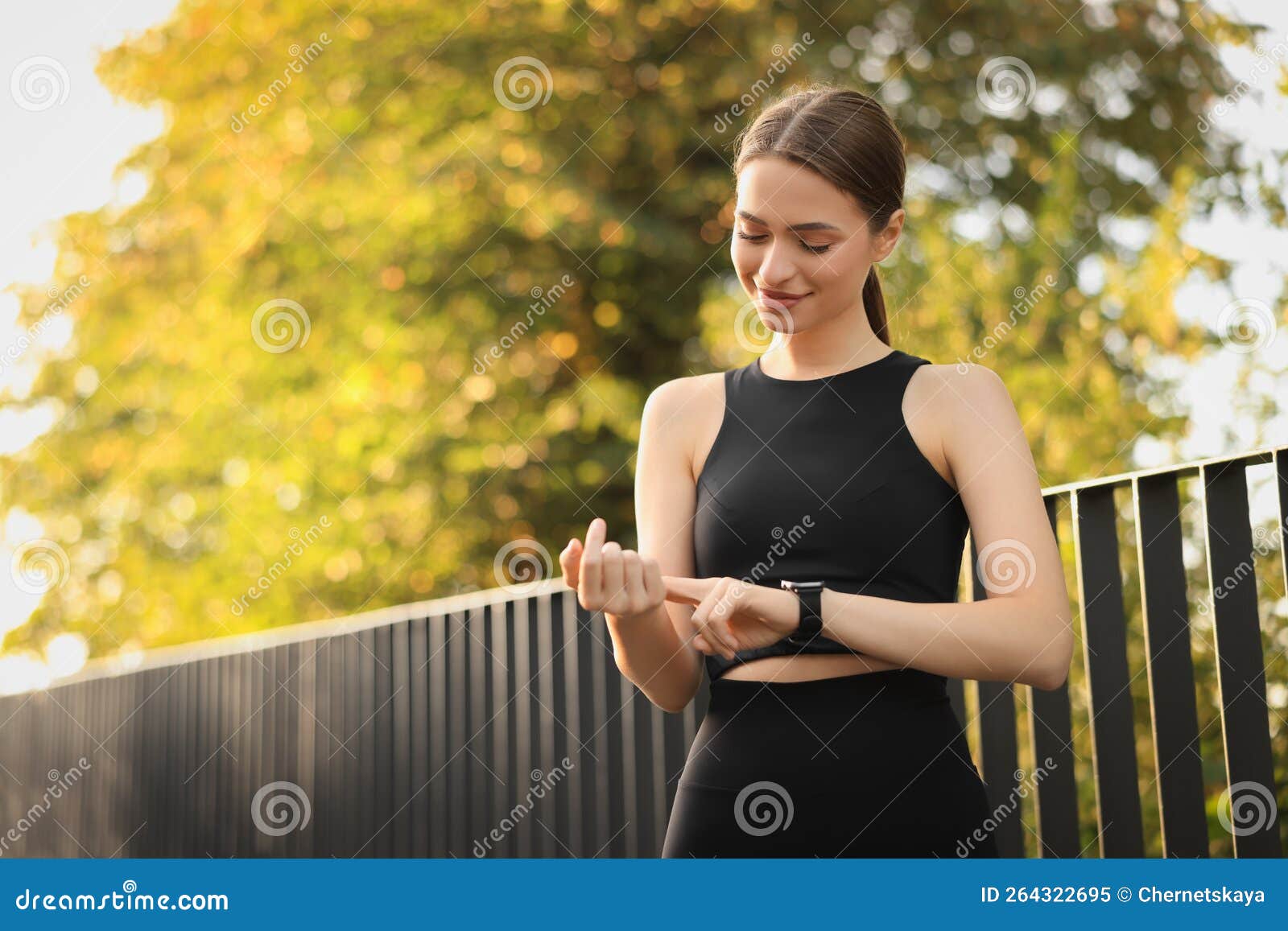 Attractive Happy Woman Checking Pulse after Training in Park. Space for ...