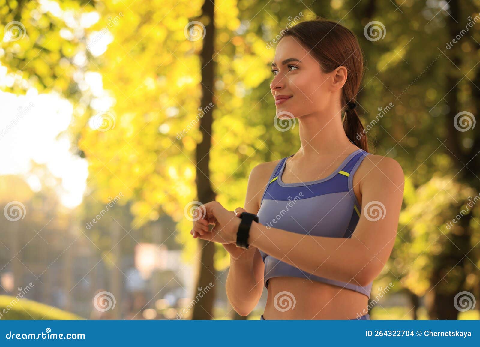 Attractive Happy Woman Checking Pulse after Training in Park on Sunny ...