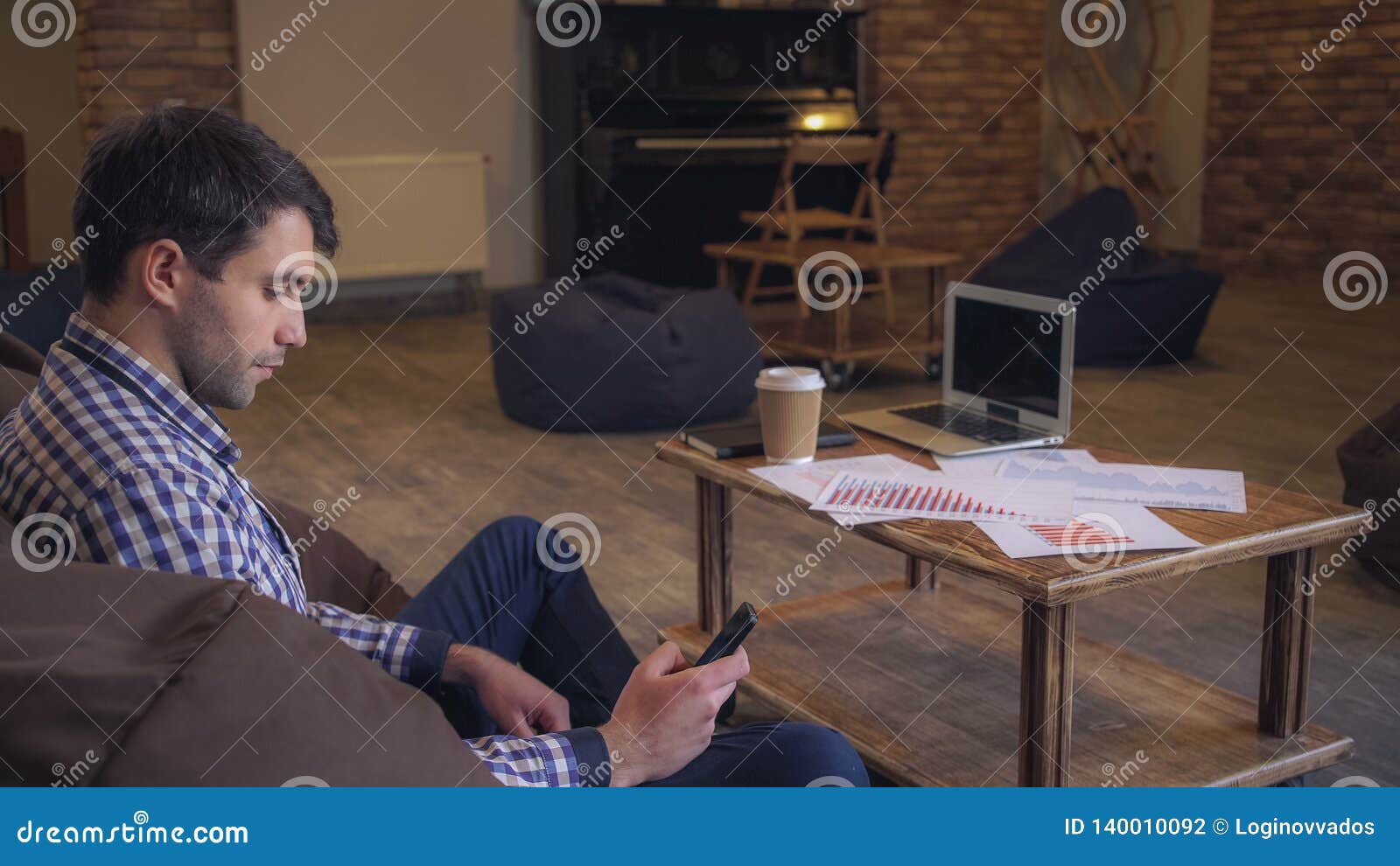 Attractive Man Check the Data on the Phone and on the Printed Document ...