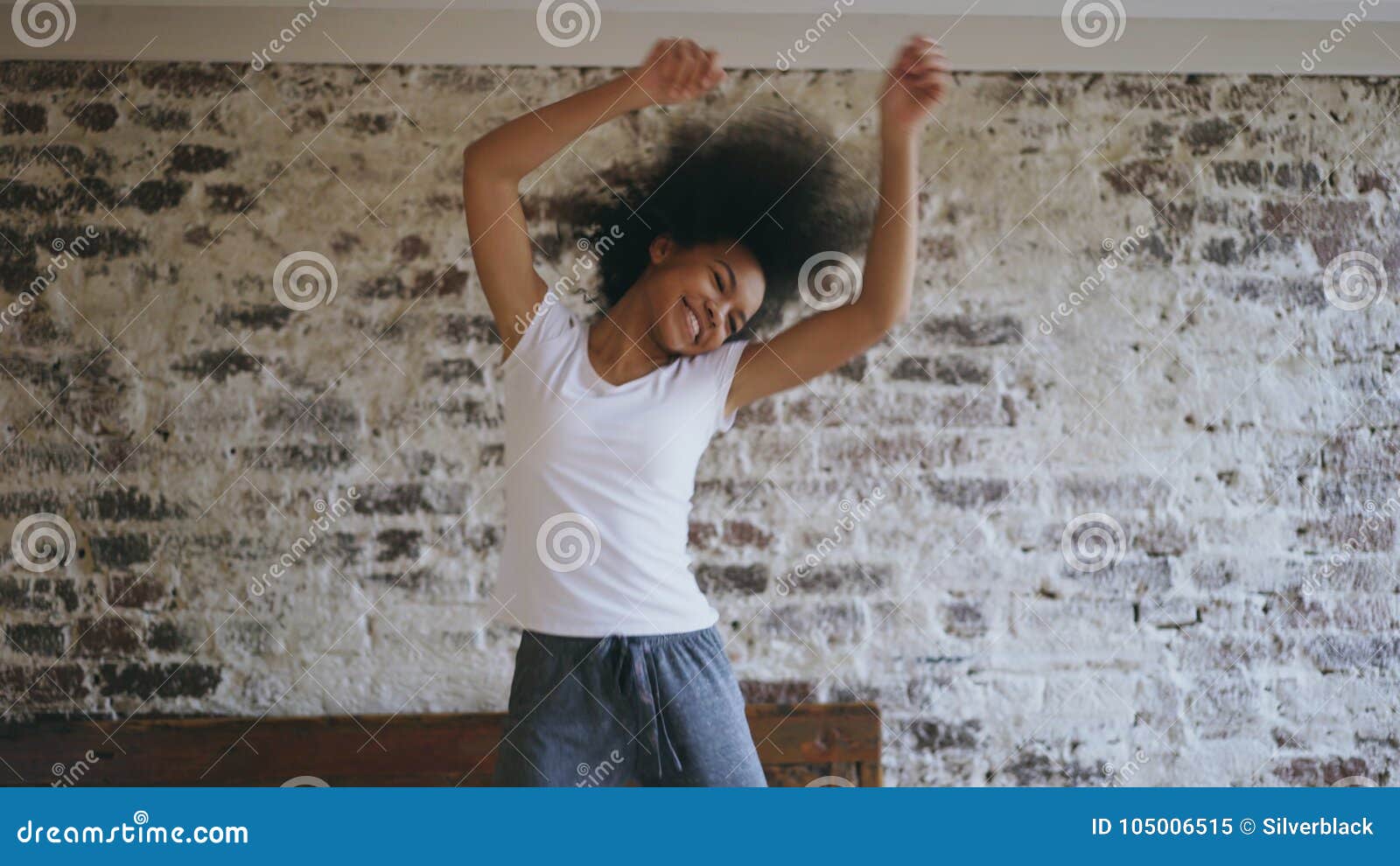 Attractive Mixed Race Young Joyful Woman Have Fun Dancing Near Bed At