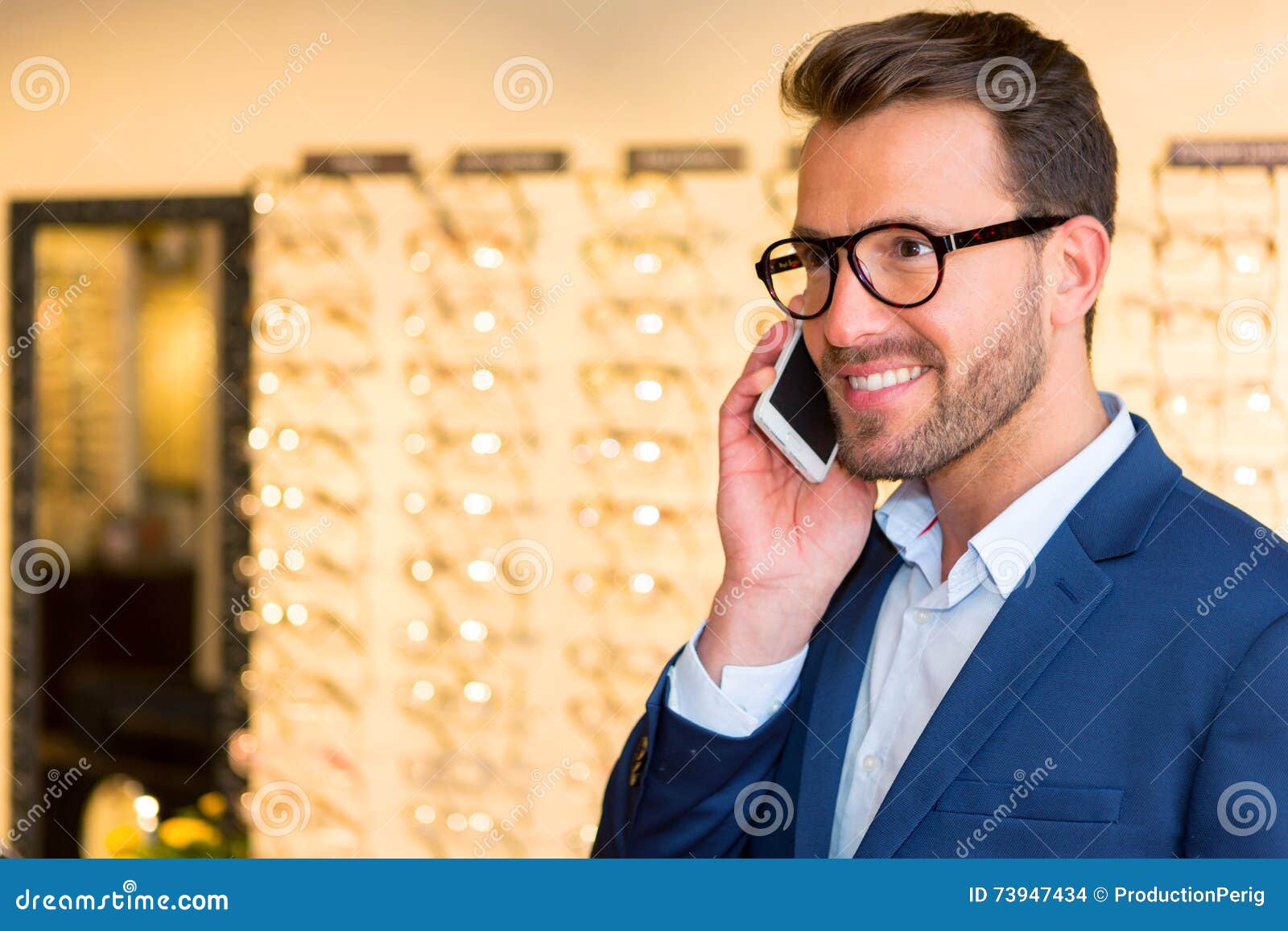 Attractive Optician Using Mobile Phone in His Glasses Shop Stock Photo ...