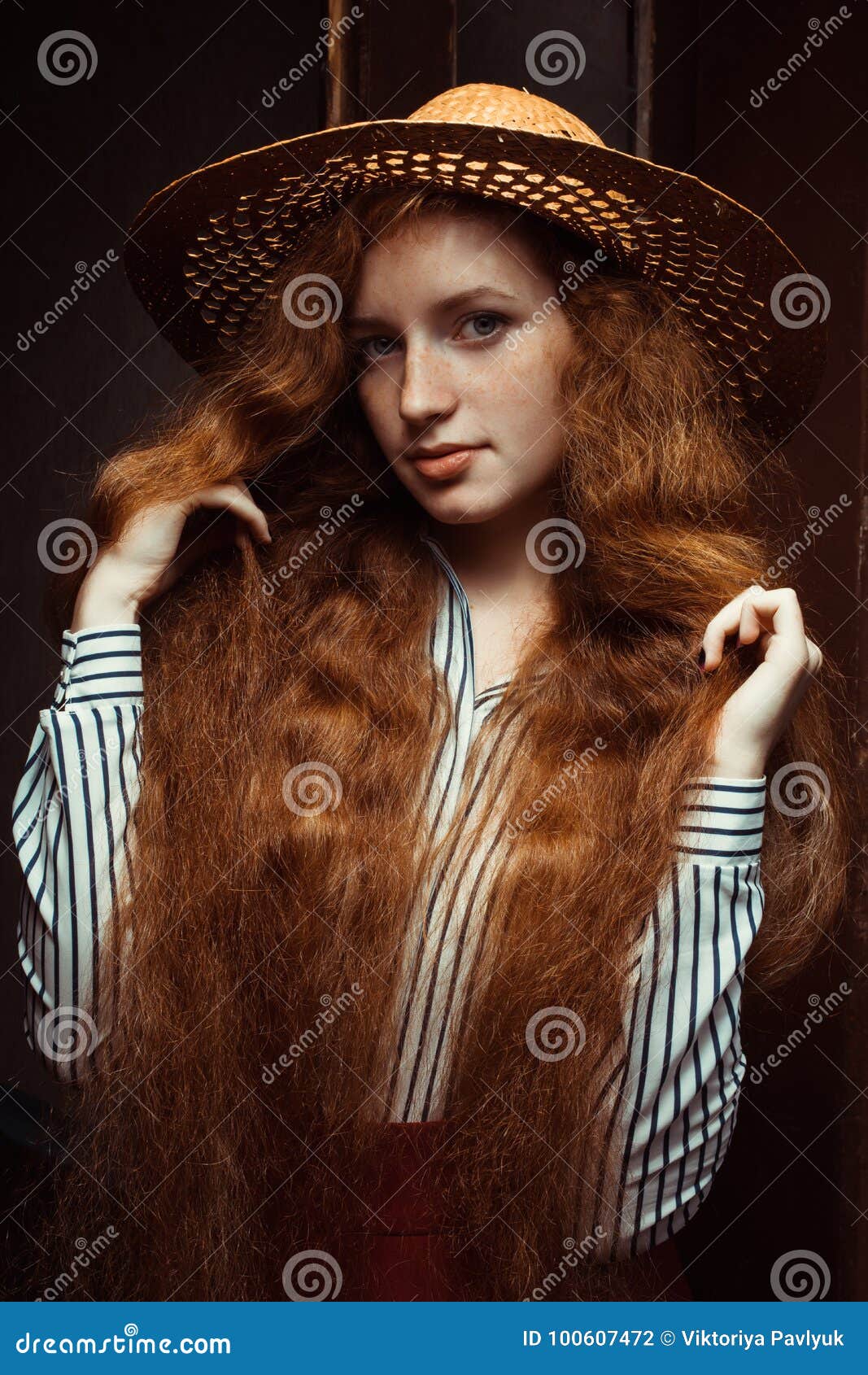 Attractive Redhead Model With Long Curly Hair In Straw Hat Posing Near