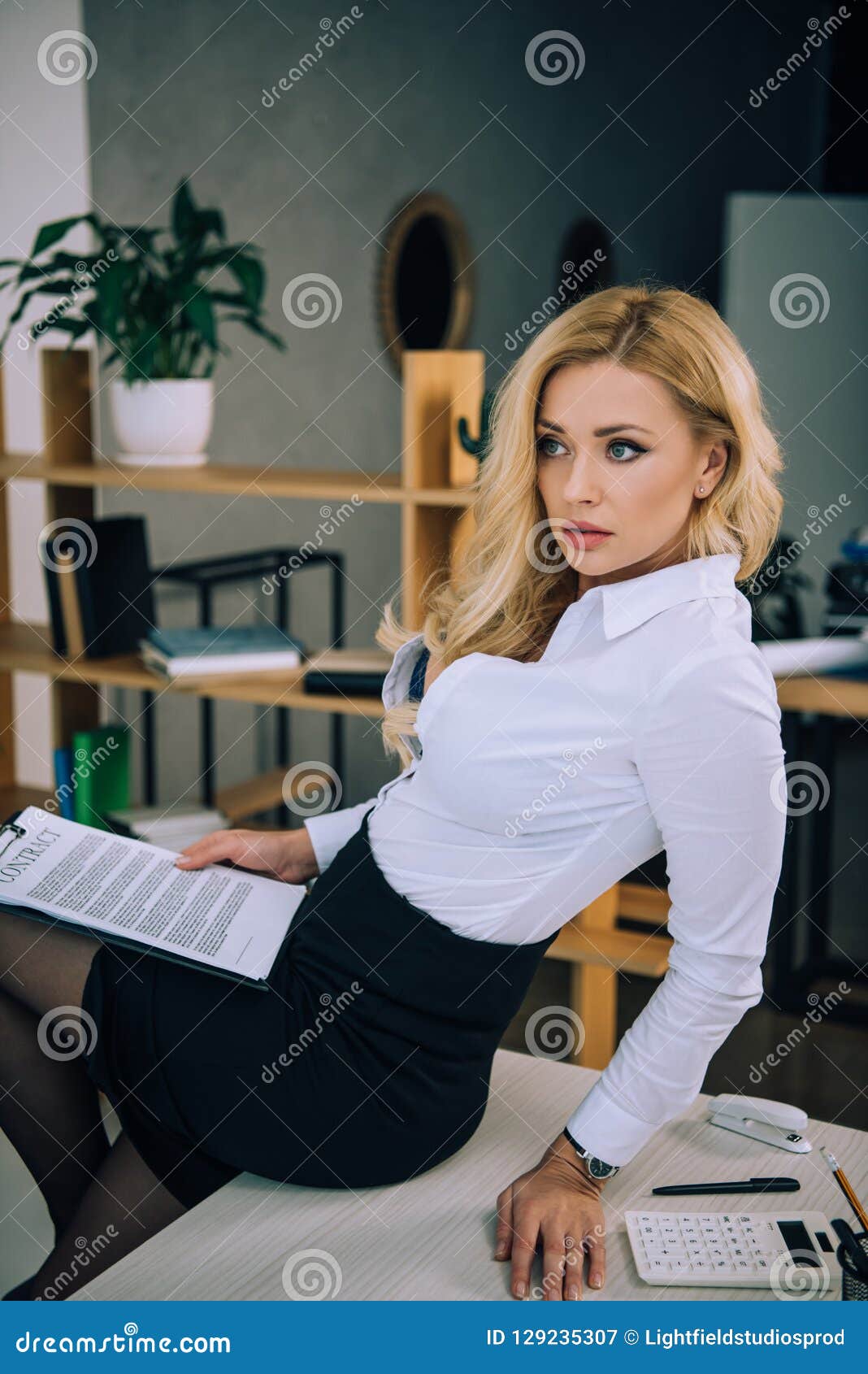 Attractive Woman Sitting on Table and Holding Stock Image - Image of ...