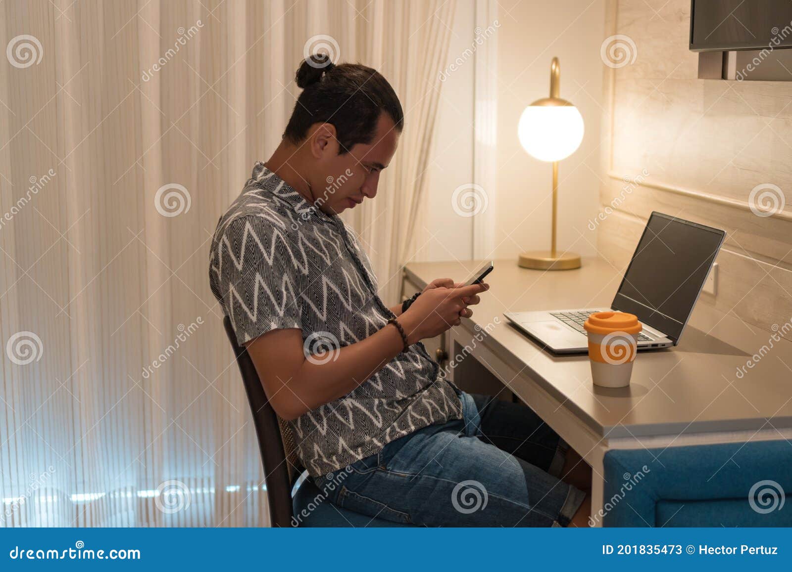 Attractive Smart Young Man Sitting at His Desk in the Bedroom, Using a ...