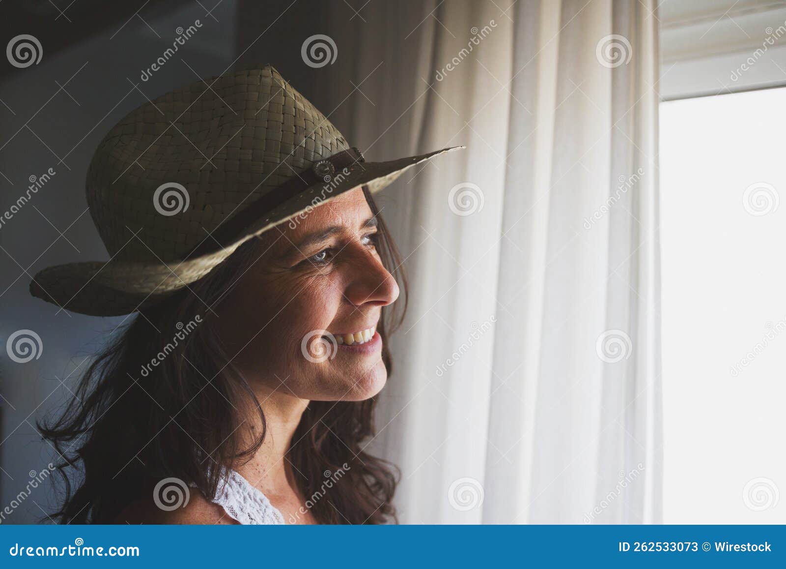 Attractive Smiling Hispanic Woman Wearing a Hat while Looking at the ...
