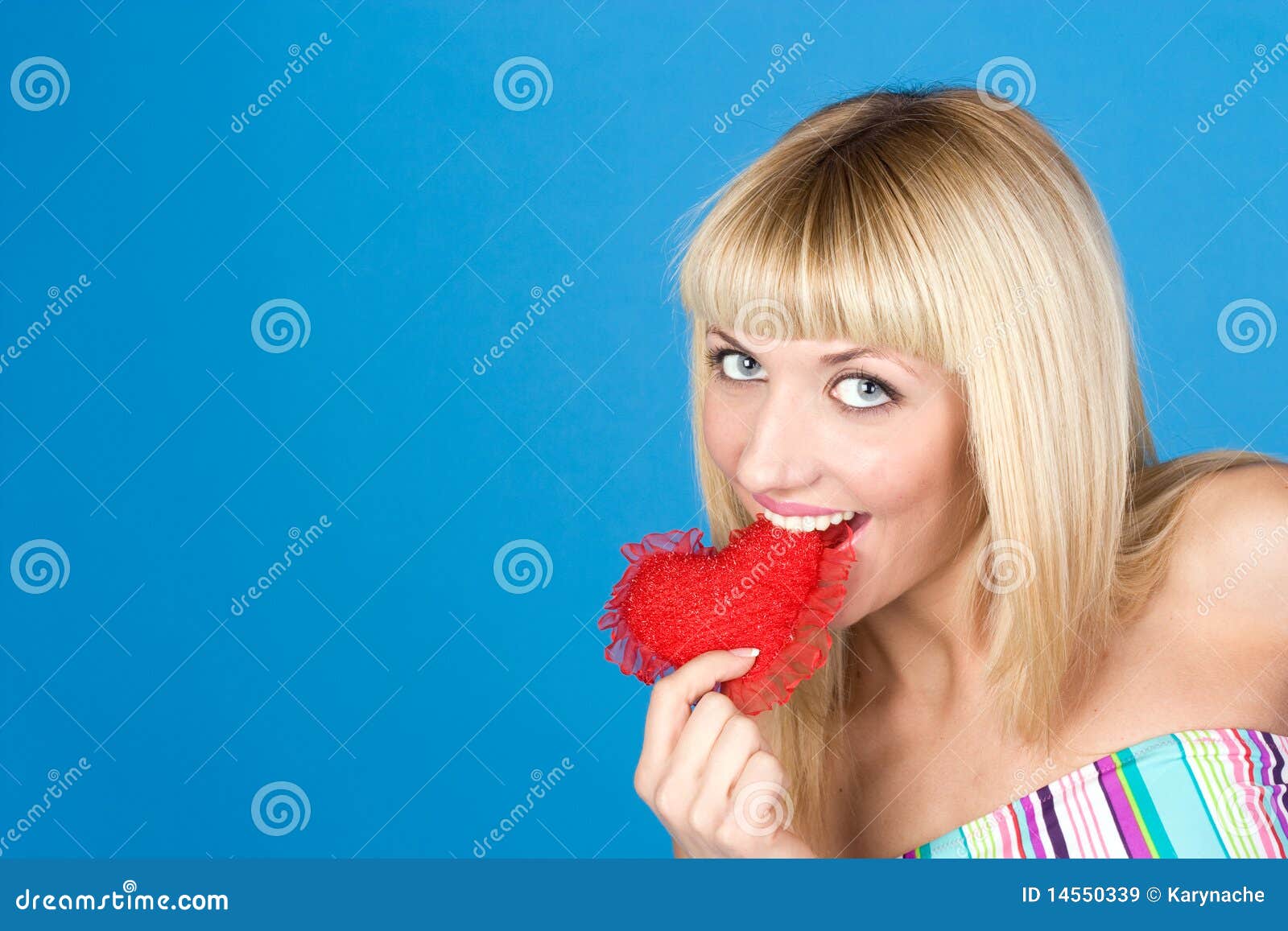 Attractive Woman Biting a Red Heart Over Blue Stock Image - Image of ...