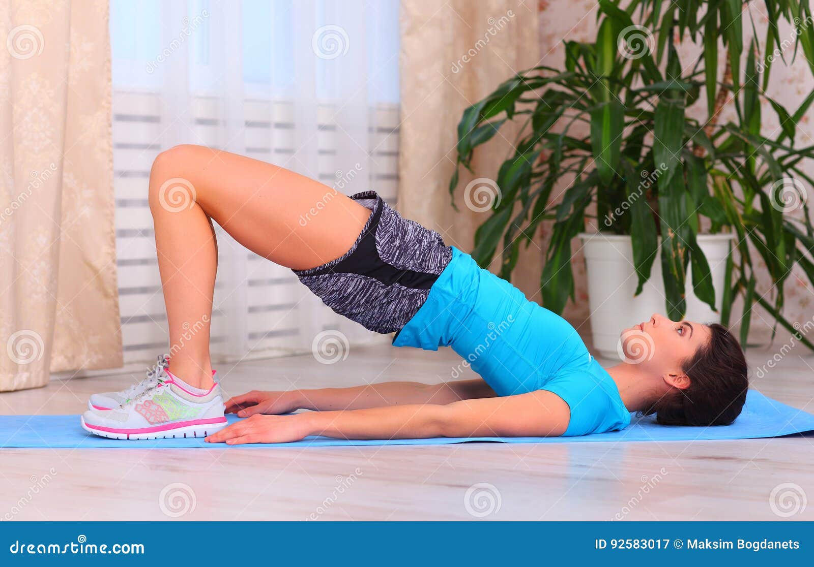 Attractive Woman Do Fitness Exercise At Home On A Blue Mat Stock Image