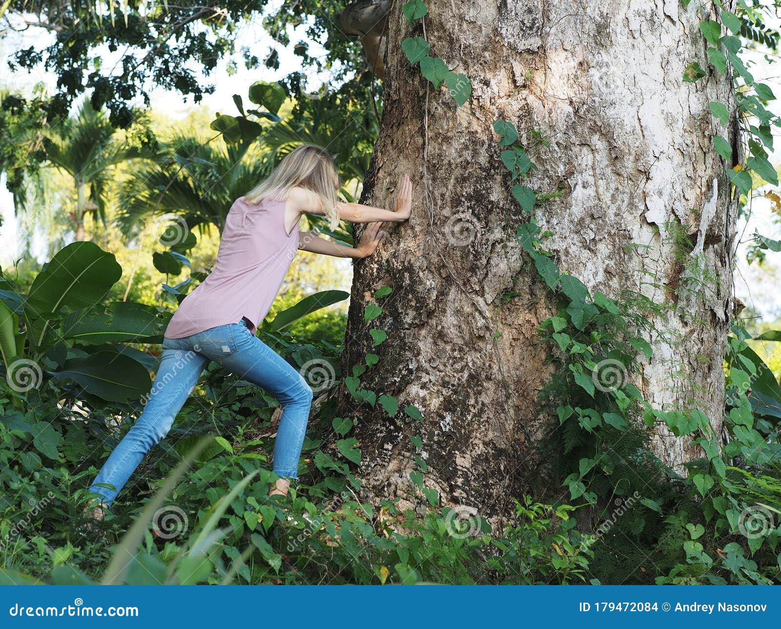 A Woman Pushes A Dry Tree Stock Image | CartoonDealer.com #74467699