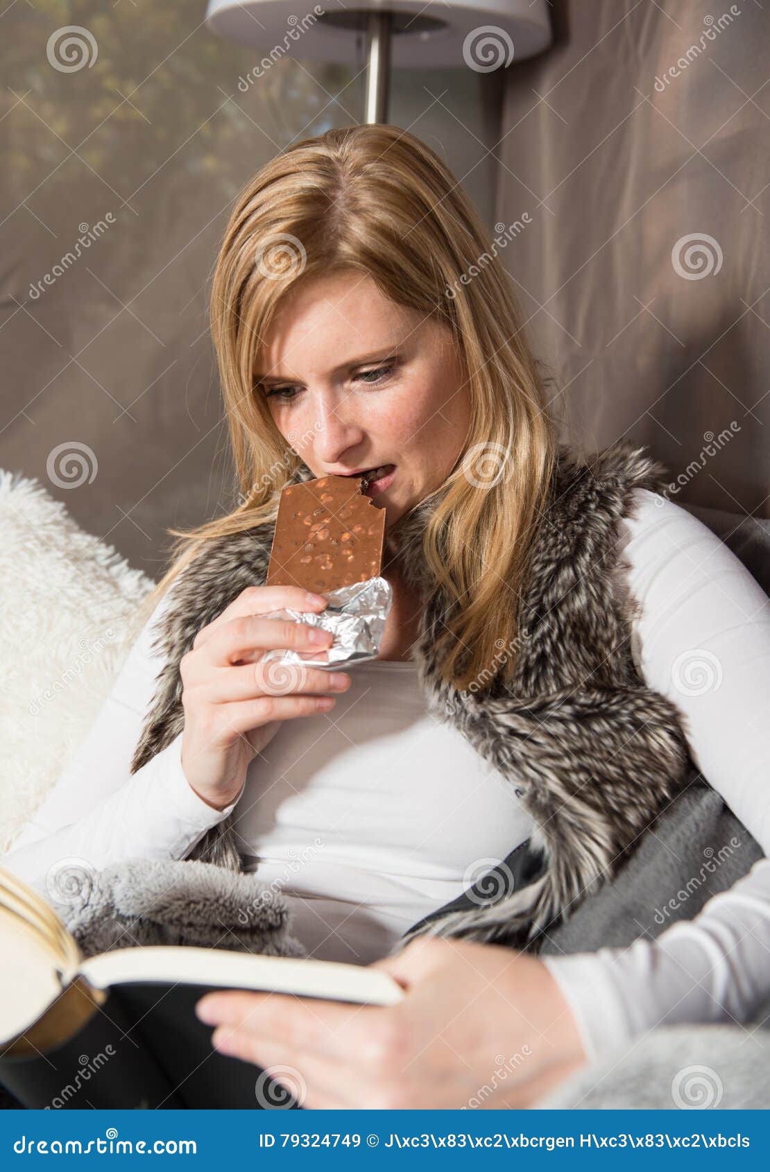 Attractive Woman Reading a Book and Eating Chocolate Stock Image ...