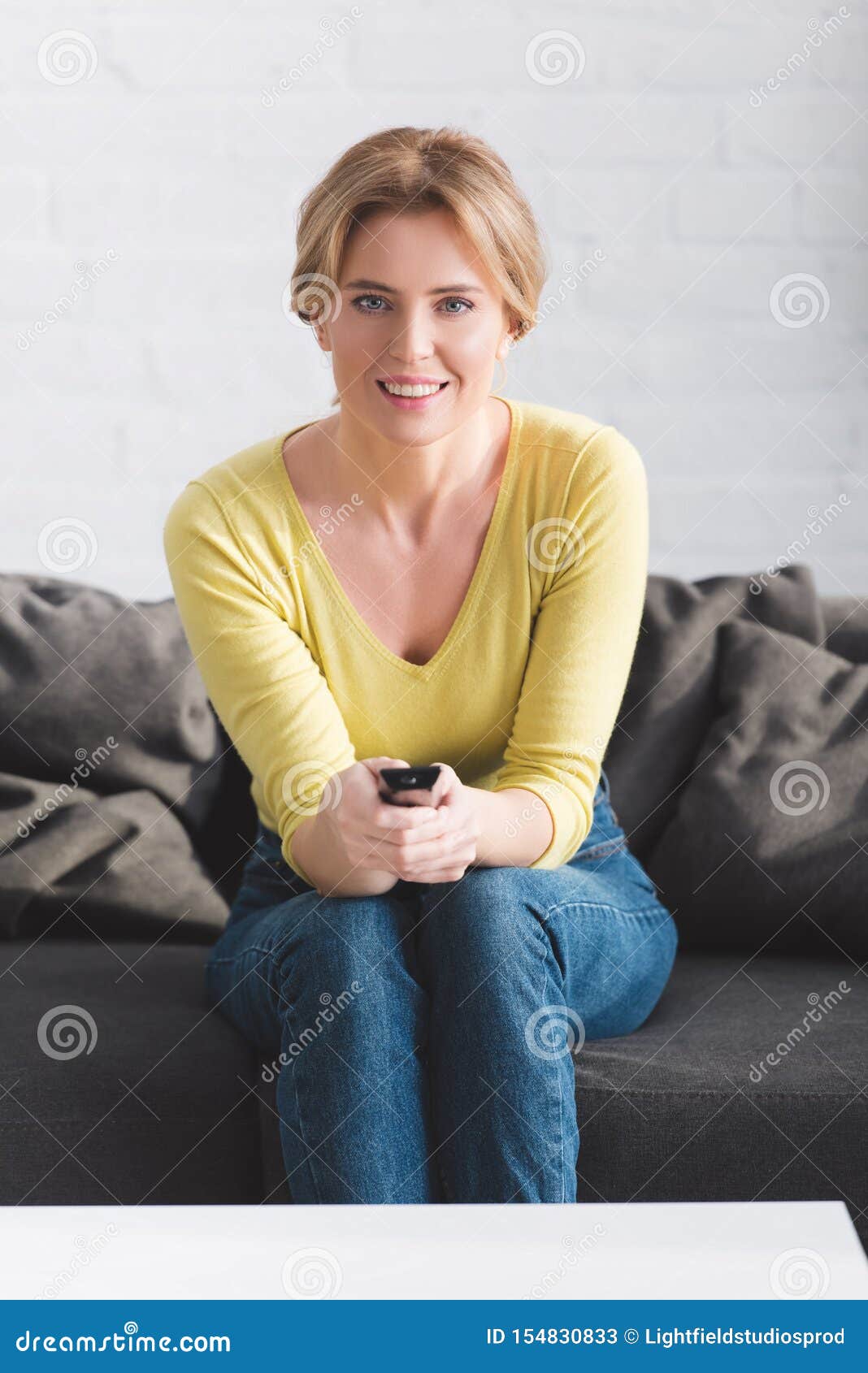 Attractive Woman Using Remote Controller and Smiling Stock Image ...
