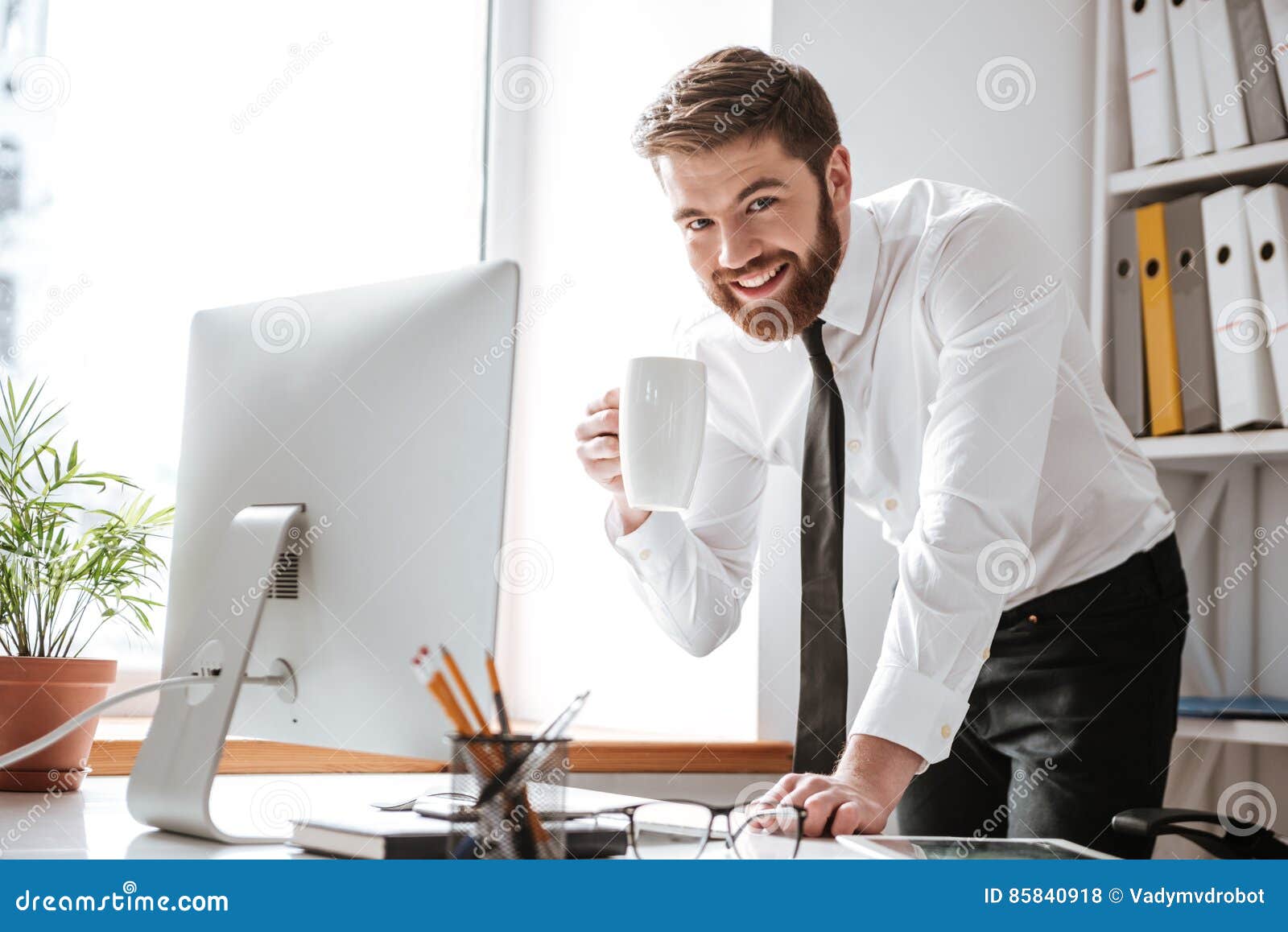 Attractive Young Businessman Drinking Tea and Using Computer. Stock ...
