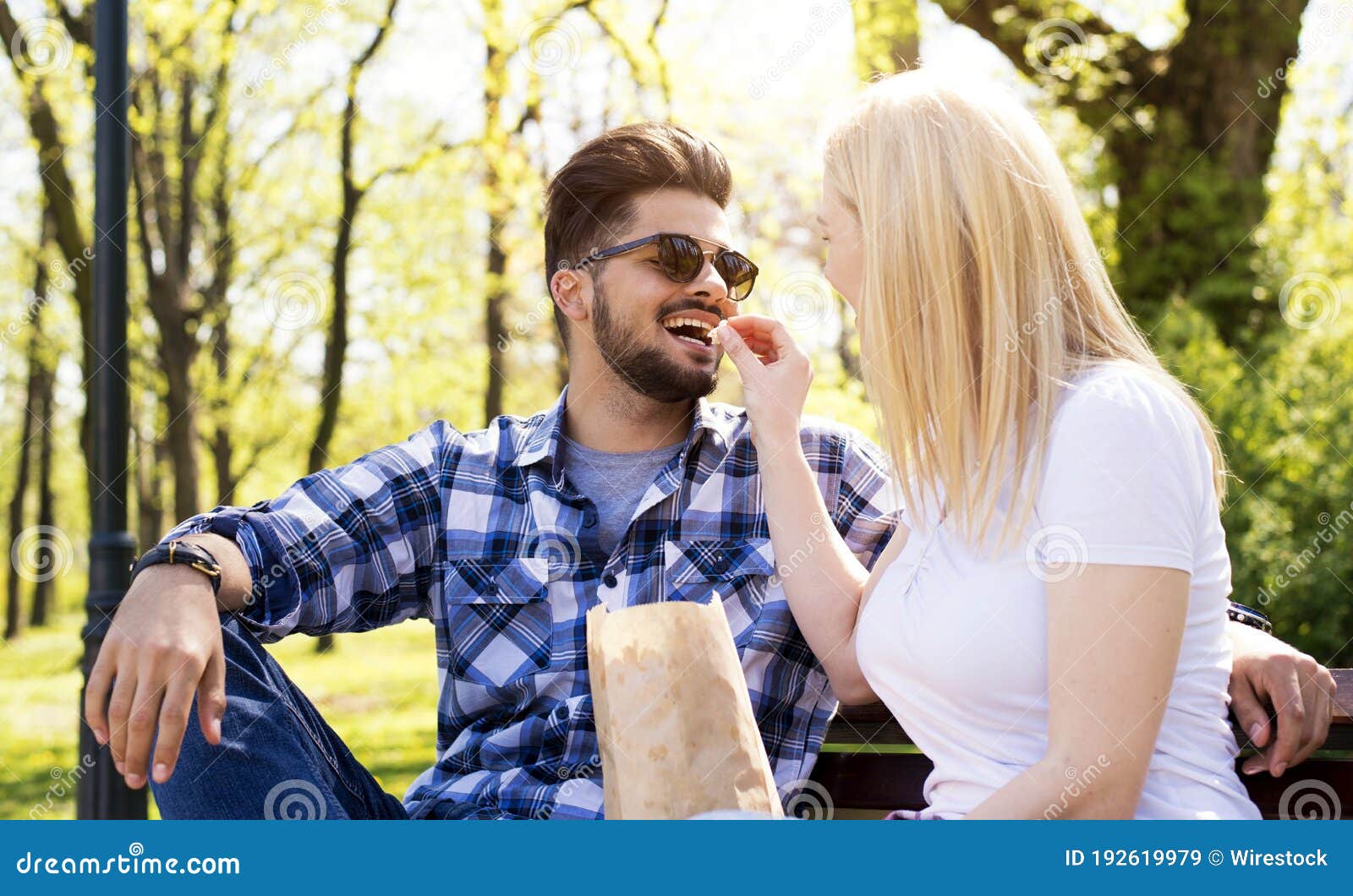 Attractive Young Couple Having Fun and Eating Popcorn on a Park Bench ...
