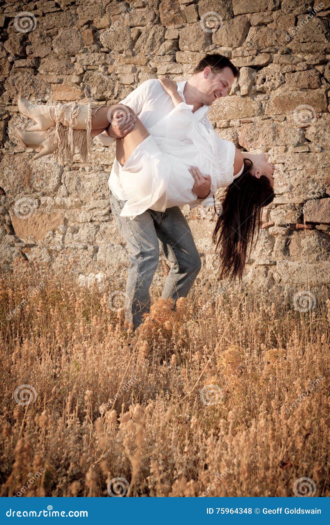 Attractive Young Couple Leaning Against Rock Wall Outdoors Having Fun ...