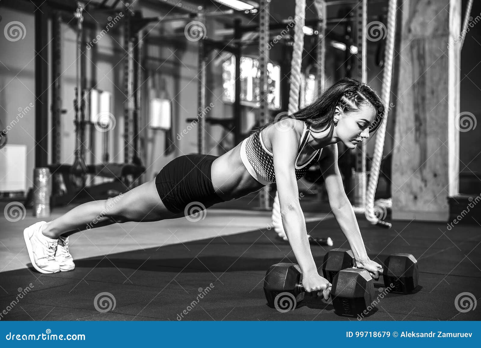 Attractive Young Woman Is Doing Plank Exercise While Working Out In Gym
