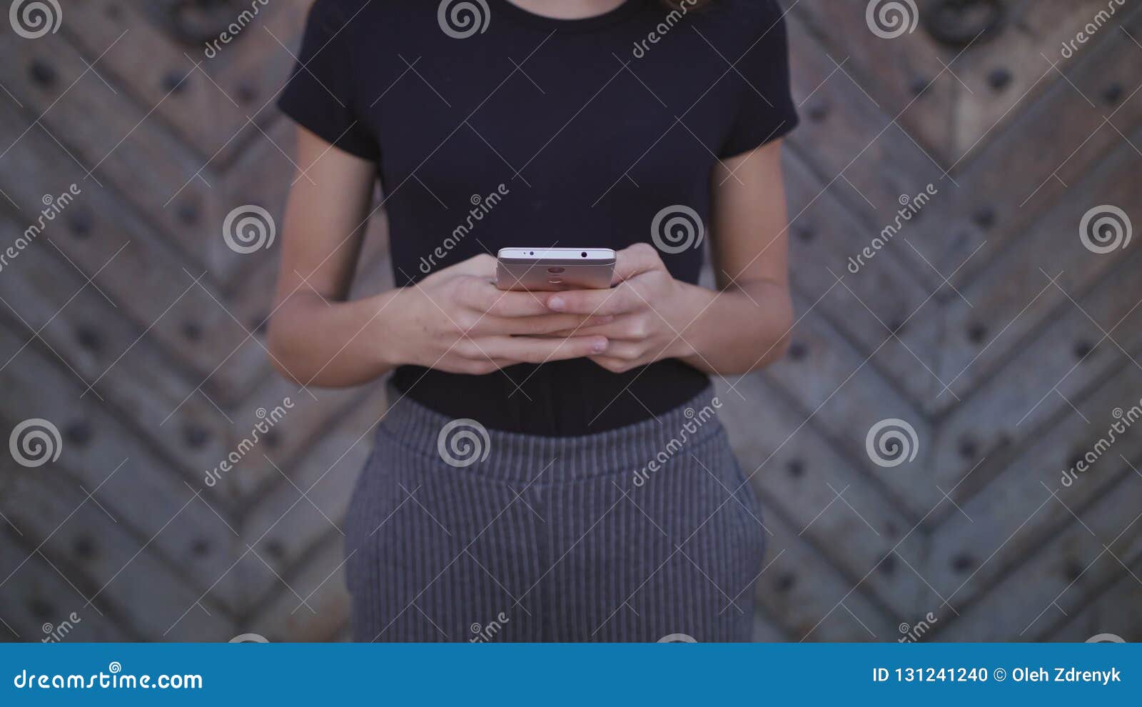 An Attractive Young Lady Using a Phone in Town. Medium Shot Stock Photo ...
