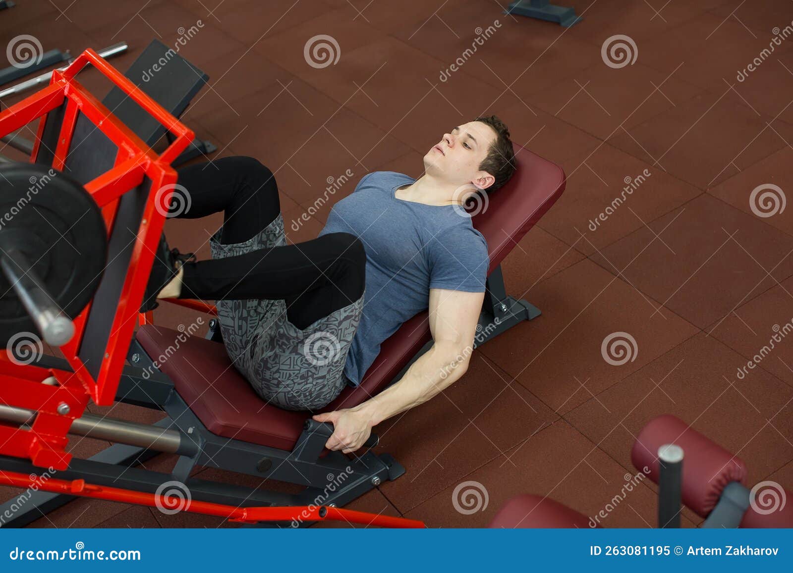 Attractive Young Man Doing Leg Press on Machine in Gym. Stock Image ...