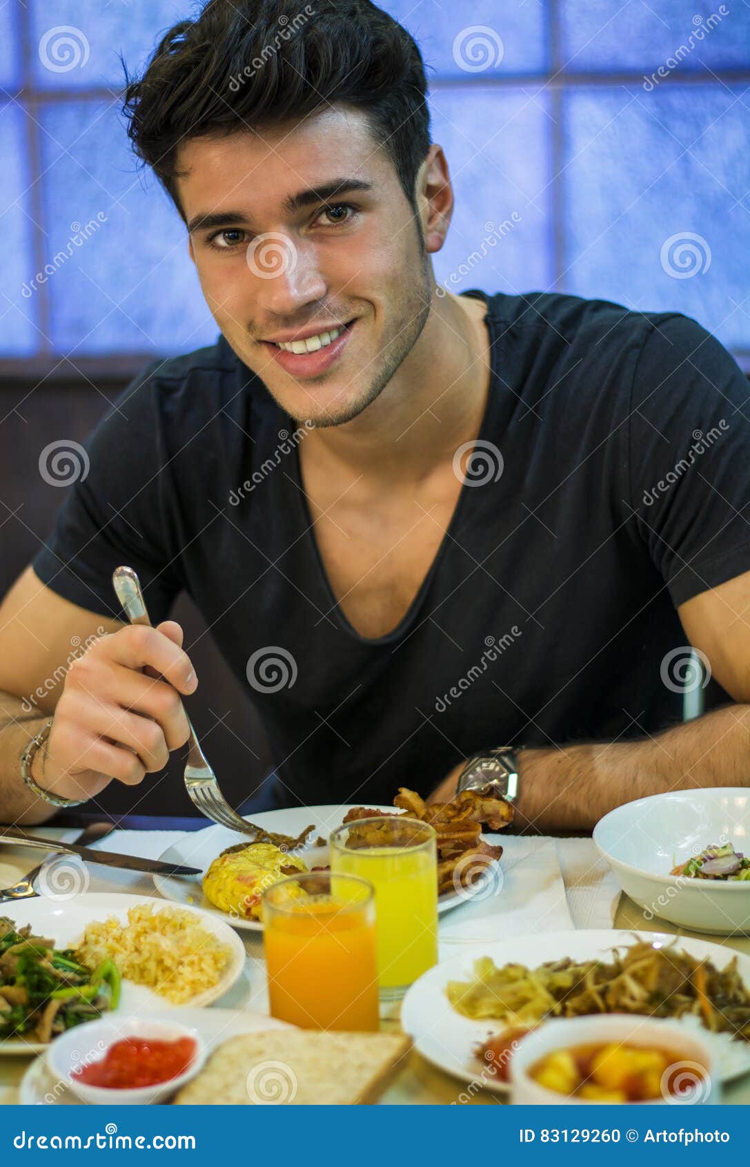 Attractive Young Man Eating Breakfast Stock Photo - Image of hand, male ...