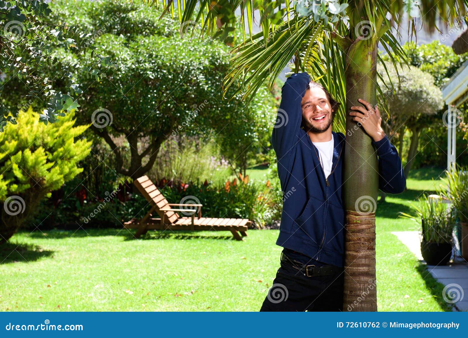 Attractive Young Man Posing by Tree in Backyard Stock Photo - Image of ...