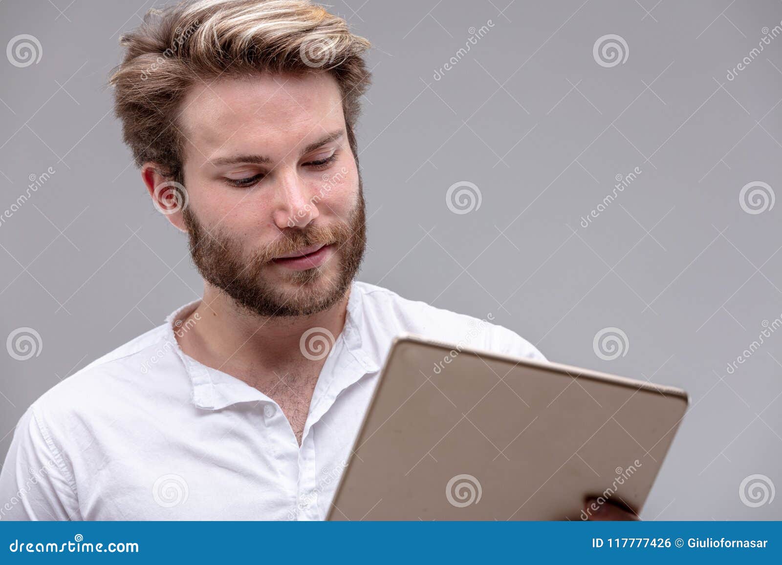 Attractive Young Man Reading on a Tablet-pc Stock Photo - Image of ...