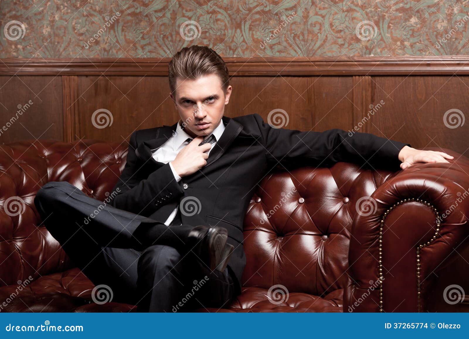 Attractive Young Man in a Suit Sitting on Couch Stock Photo - Image of ...