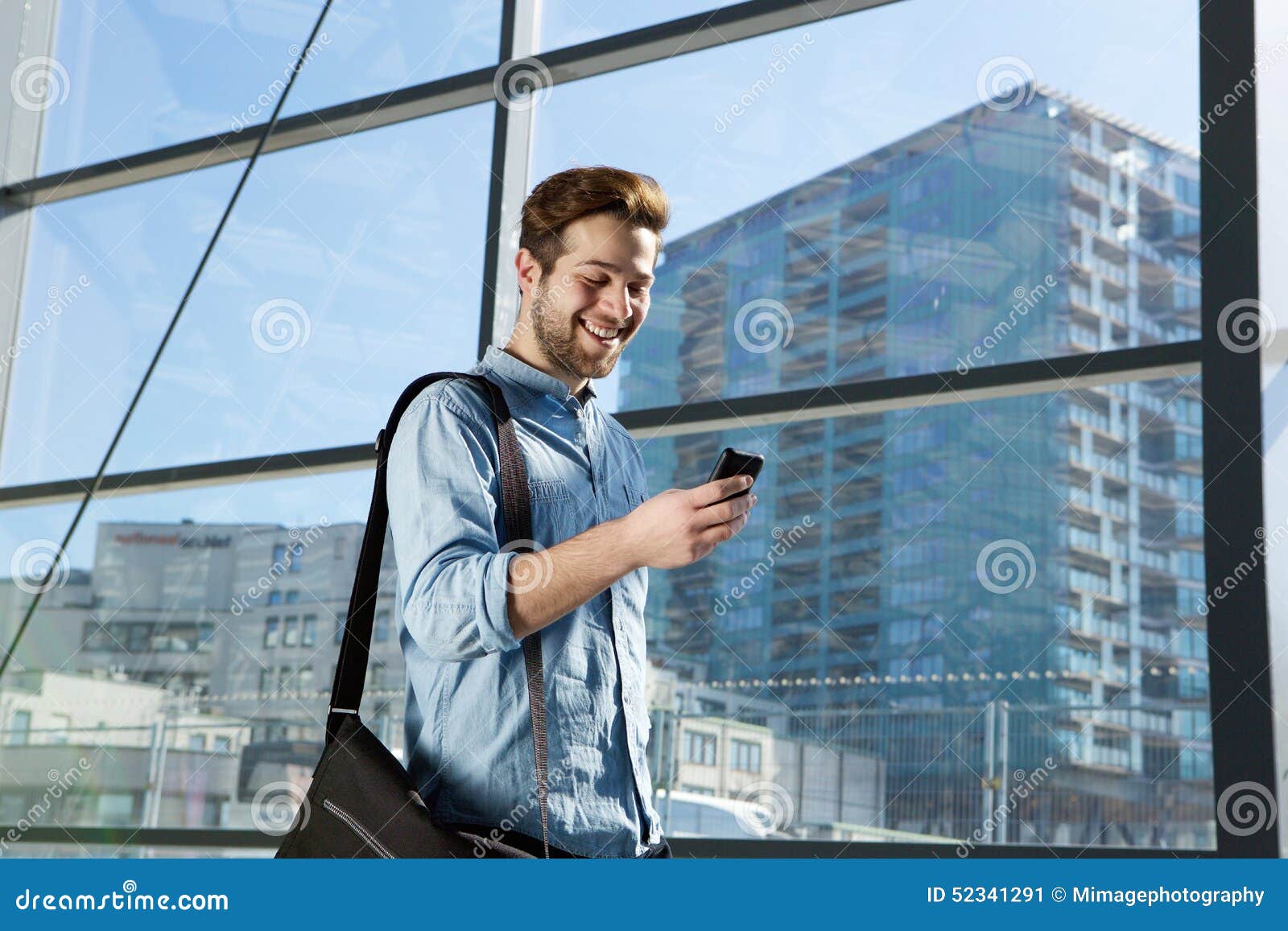 Attractive Young Man Walking and Looking at Mobile Phone Stock Image ...