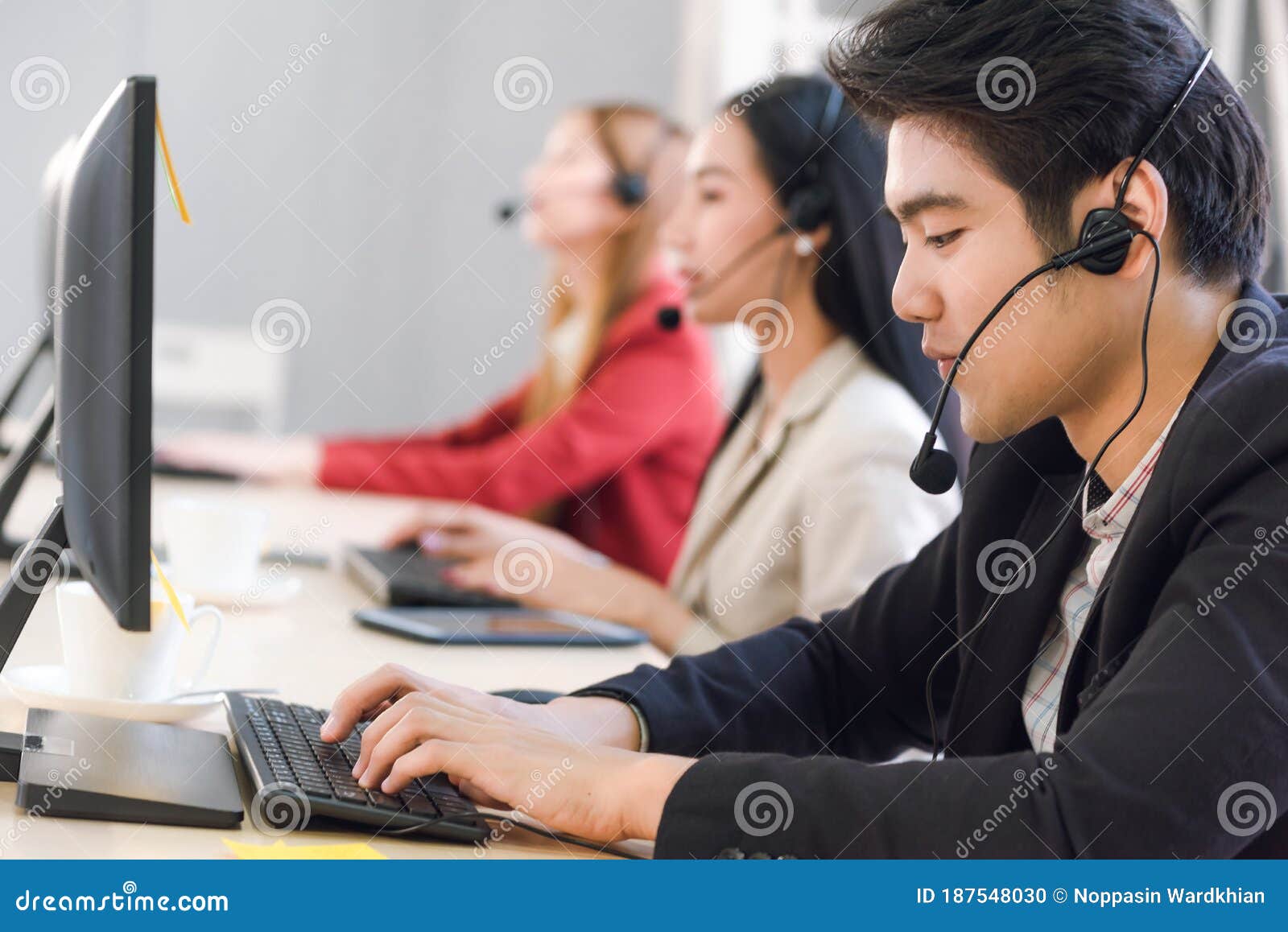Attractive Young Man Working in a Call Center with His Colleagues Stock ...