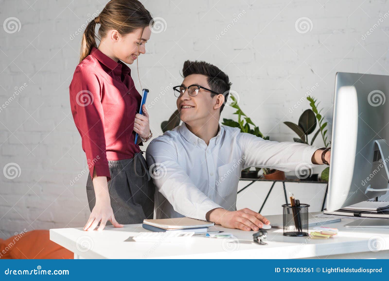 Attractive Young Managers Working with Computer Together at Workplace ...