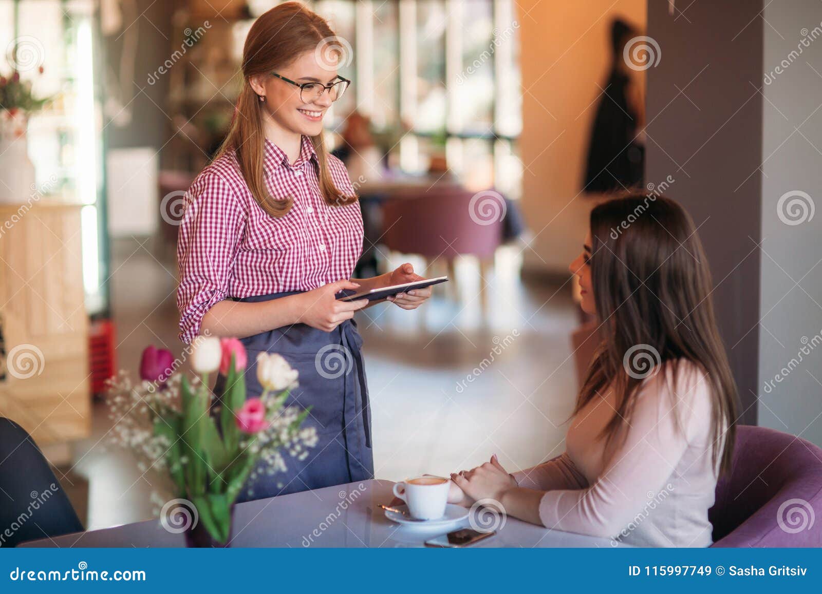 Attractive Young Waitress Using a Tablet Computer To Take an Order from ...