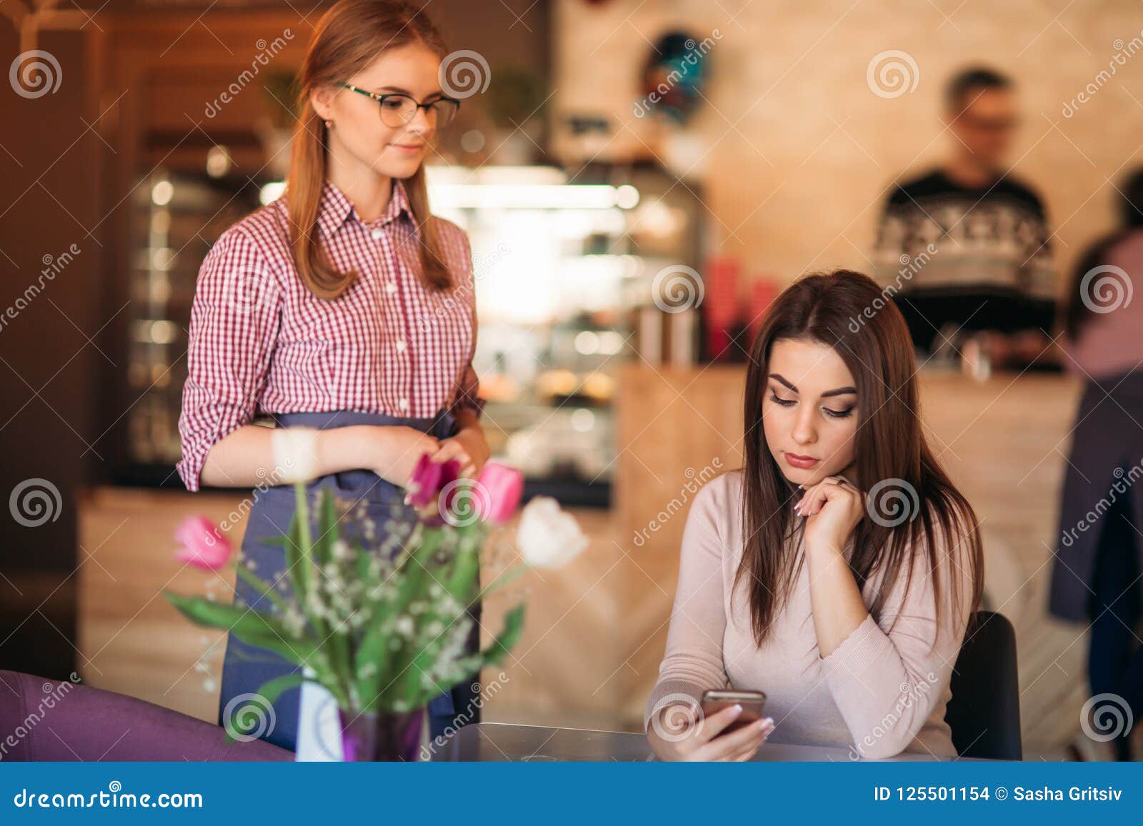 Attractive Young Waitress Using a Tablet Computer To Take an Order from ...
