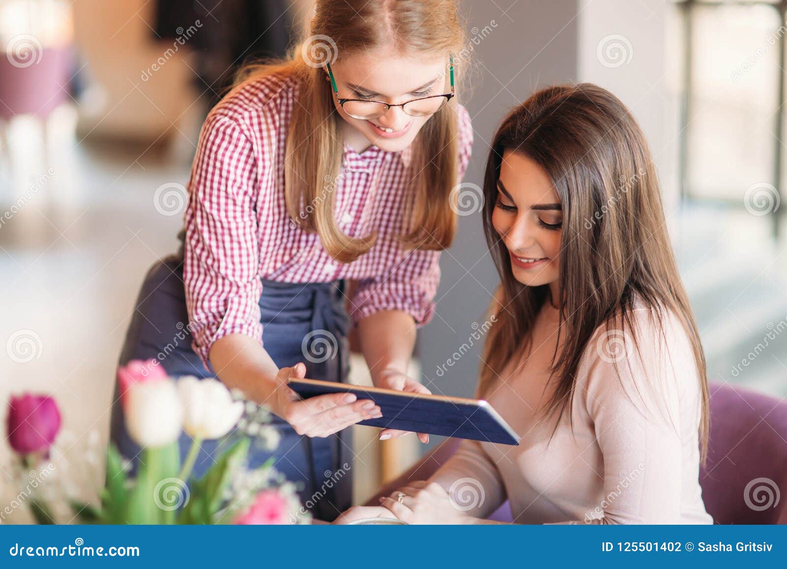 Attractive Young Waitress Using a Tablet Computer To Take an Order from ...