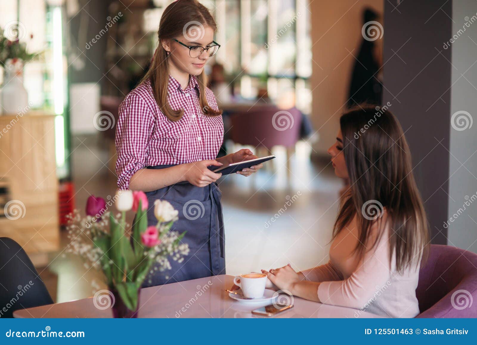 Attractive Young Waitress Using a Tablet Computer To Take an Order from ...
