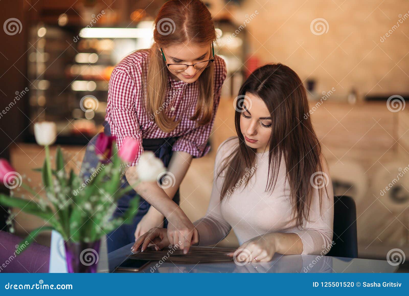 Attractive Young Waitress Using a Tablet Computer To Take an Order from ...